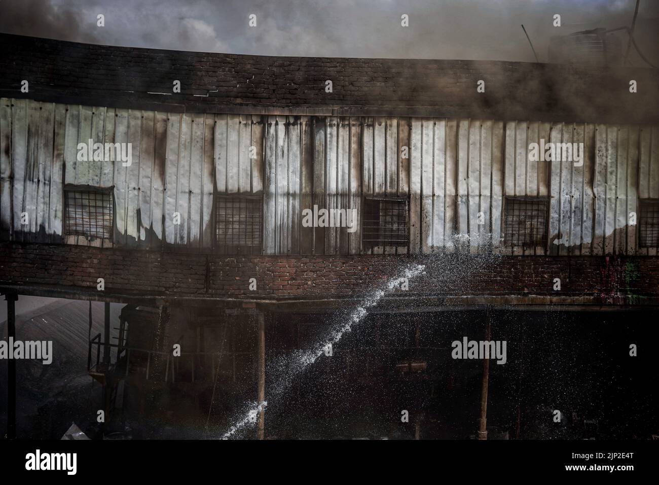 Firefighters try to extinguish a fire inside the building at a plastic ...