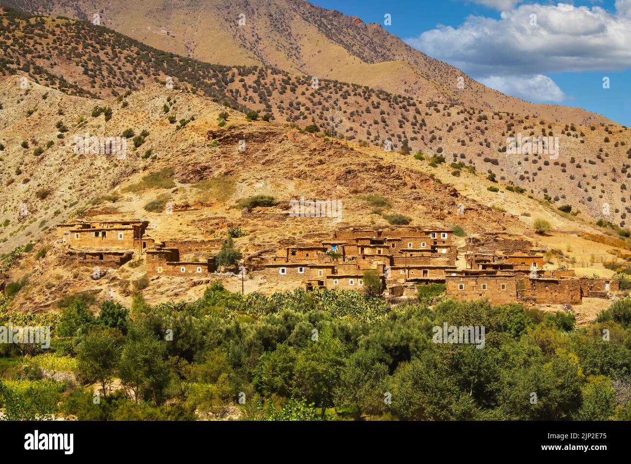 Beautiful unknown clay house village, green trees in Atlas mountains ...