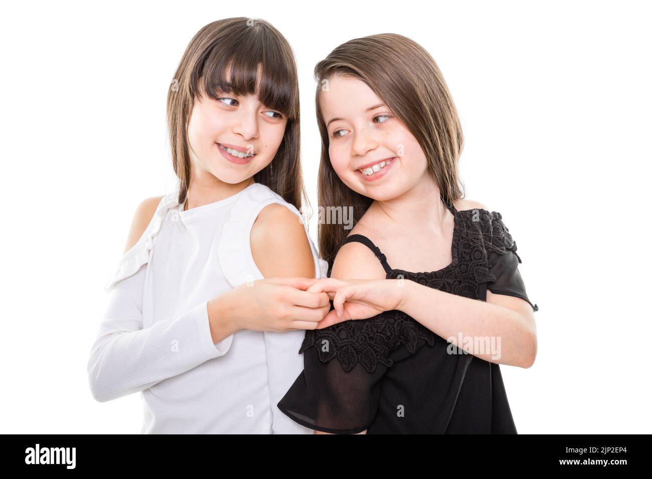 Two cute girls with happy faces posing in a studio with white ...