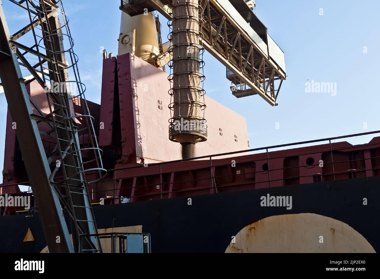Loading grain into holds of sea cargo vessel in seaport from grain ...
