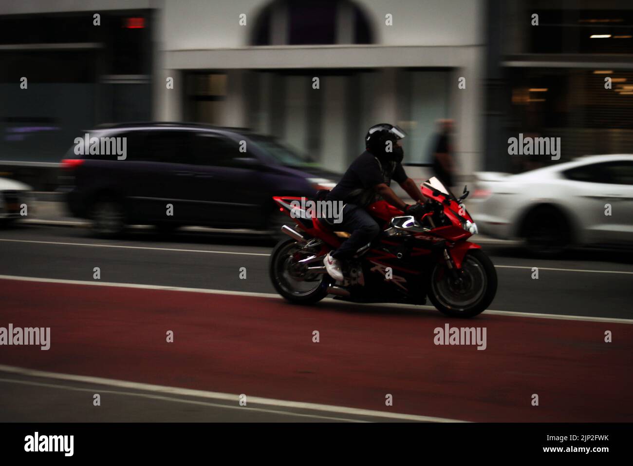 A motorcycle riding fast through the streets of New York at evening ...
