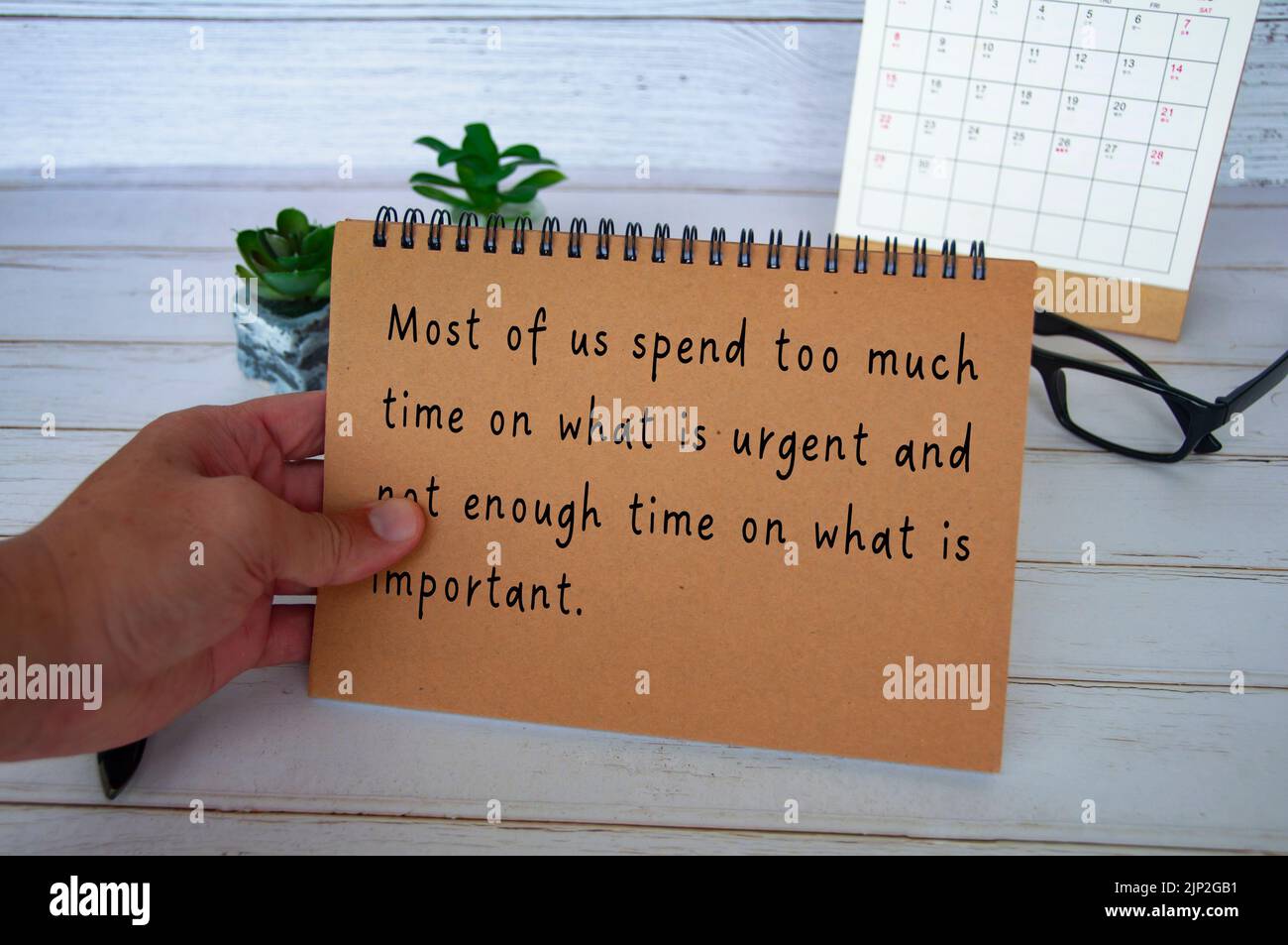 Hand holding brown notepad with motivational quotes text about time ...