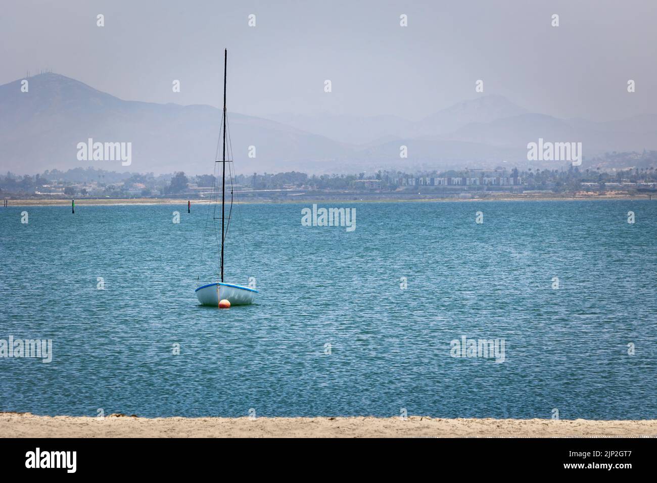 An empty sailboat sits moored to a buoy in San Diego Bay in California ...