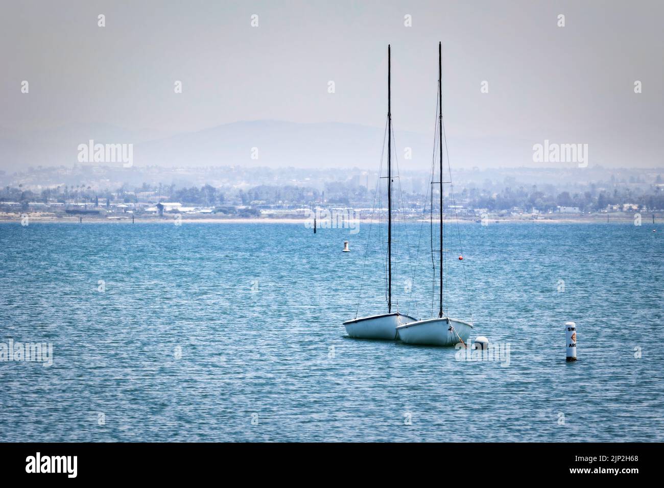 Two empty sailboats sits moored to buoys in San Diego Bay in California ...