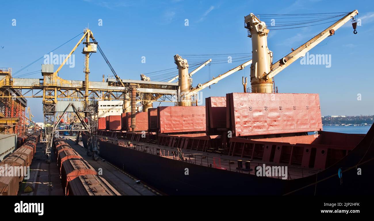 Loading grain into holds of sea cargo vessel in seaport from grain ...