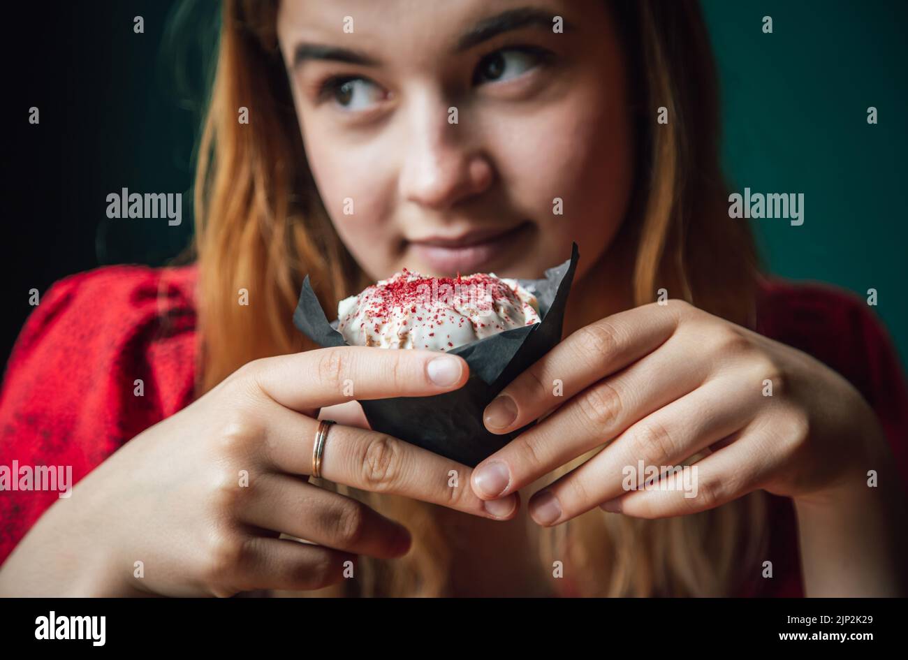A young woman enjoys a raspberry muffin in a cafe Stock Photo - Alamy