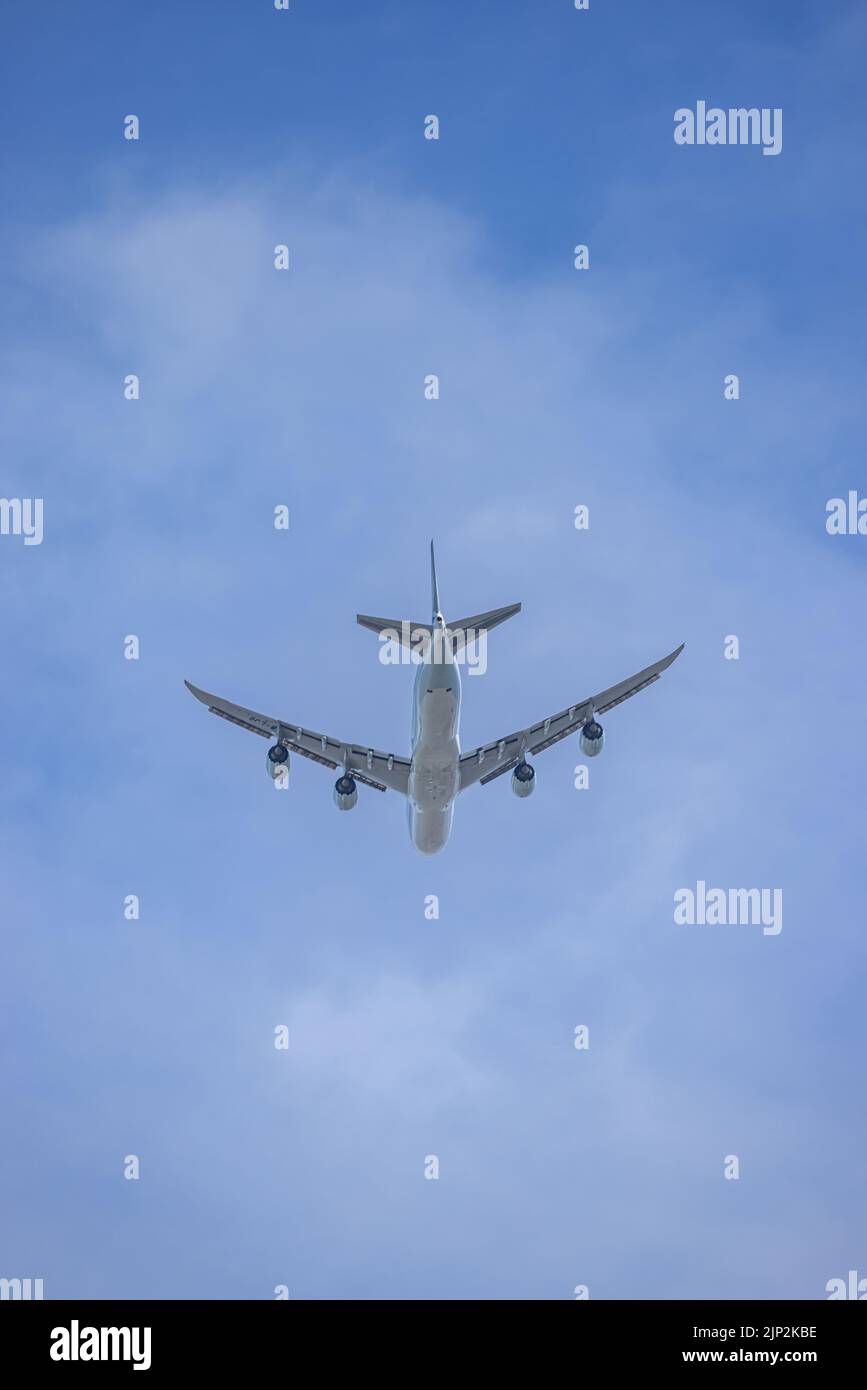 A vertical low angle of a big airplane under a blue cloudy sky Stock ...