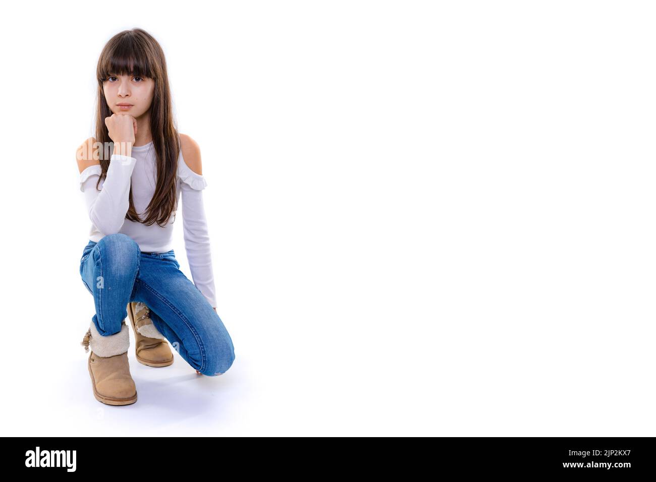 A beautiful young brunette girl look straight into camera with hand ...