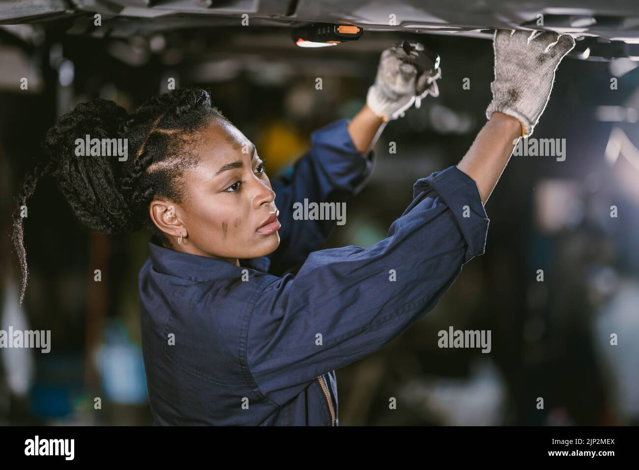 Black african woman mechanic staff worker work service under car in ...