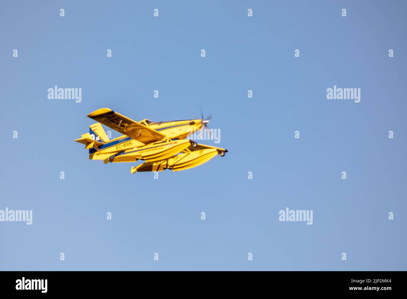 A small yellow hydro plane for fire extinction flying to pour water on ...