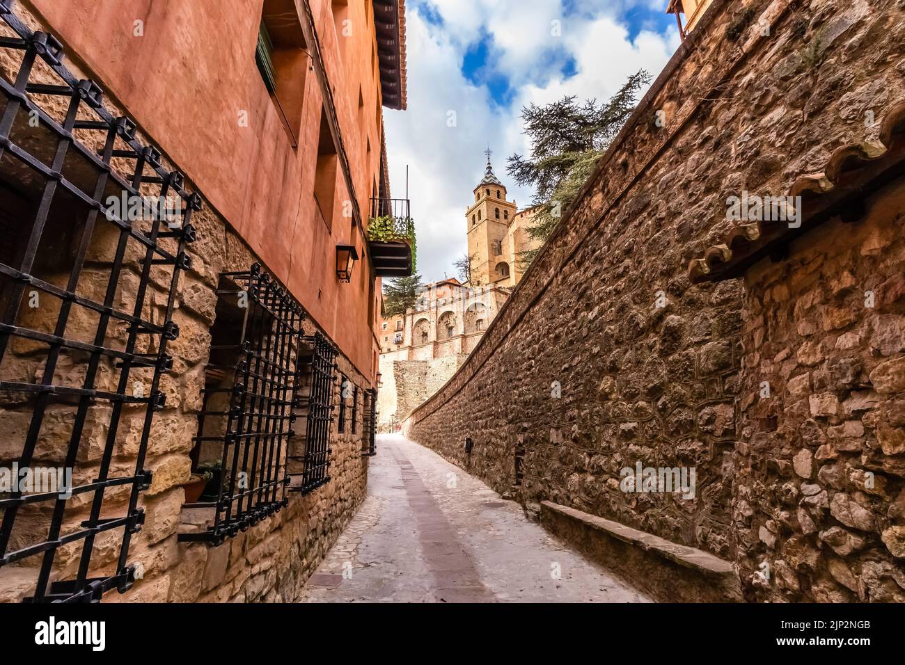 Alley between stone walls and barred windows leading to the town's ...