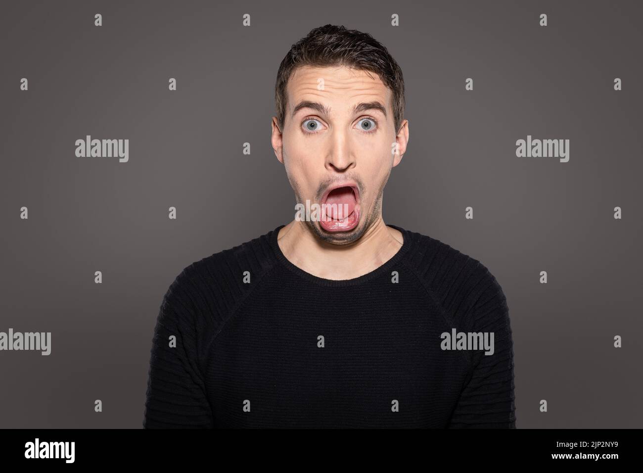 A closeup of grotesque face with open mouth of an adult man isolated on ...