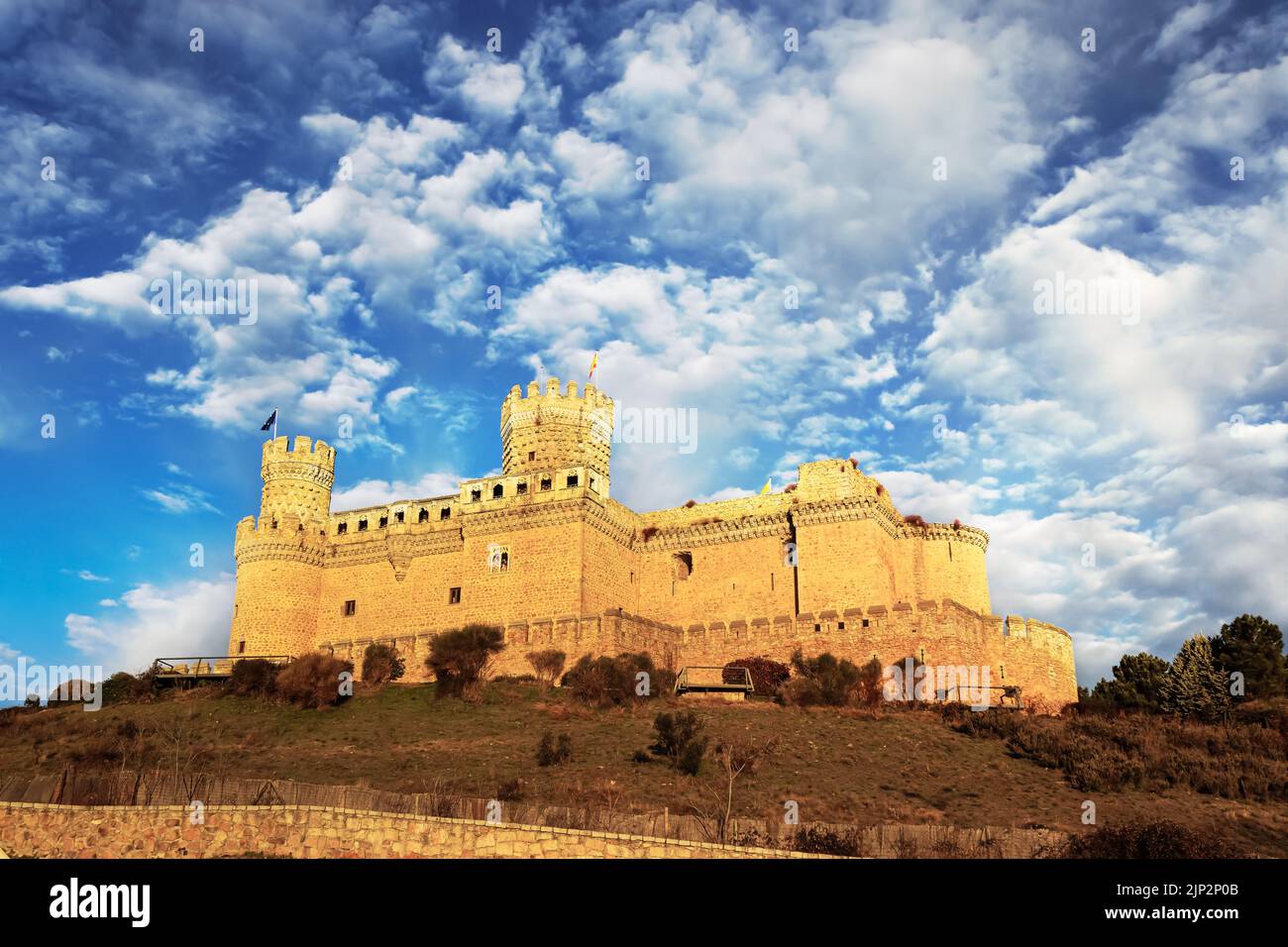 Medieval castle on the mountain, tower with flag, blue sky and clouds ...