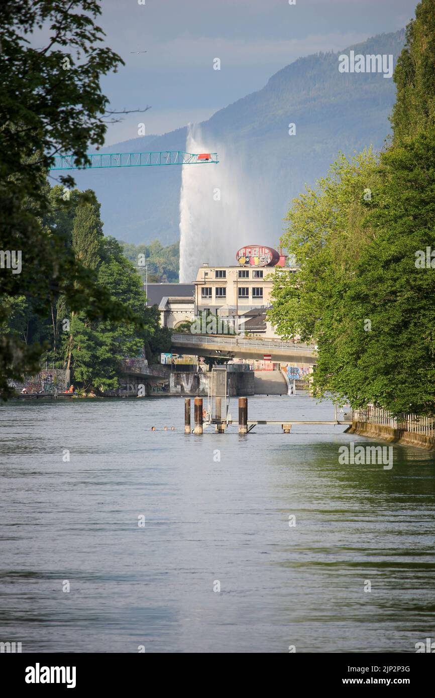 A vertical of the Geneva Water Fountain against buildings and a ...