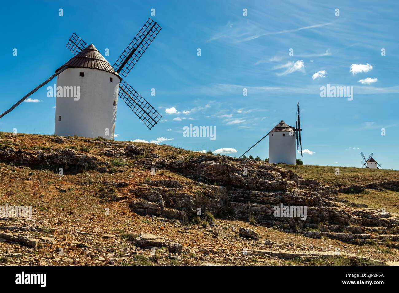 Old White Windmills Made Of Stone On The Field With Blue Sky And White Clouds La Mancha