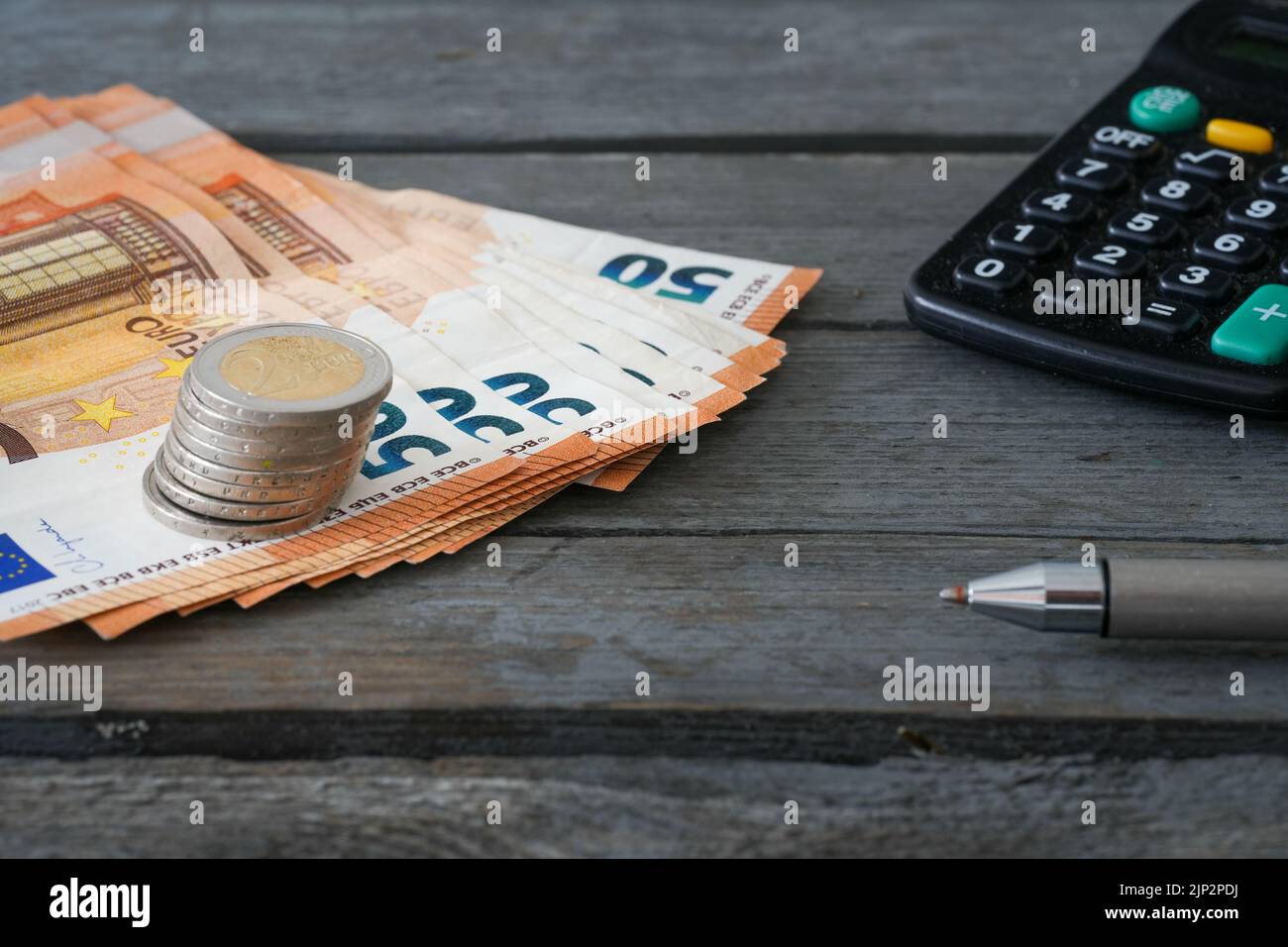 The euro money with calculator and pen on a wooden background with the ...