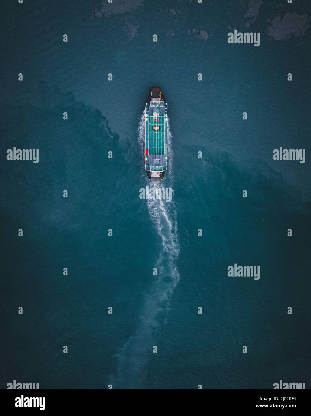 An aerial drone photo of an empty container cargo ship cruising in blue ...