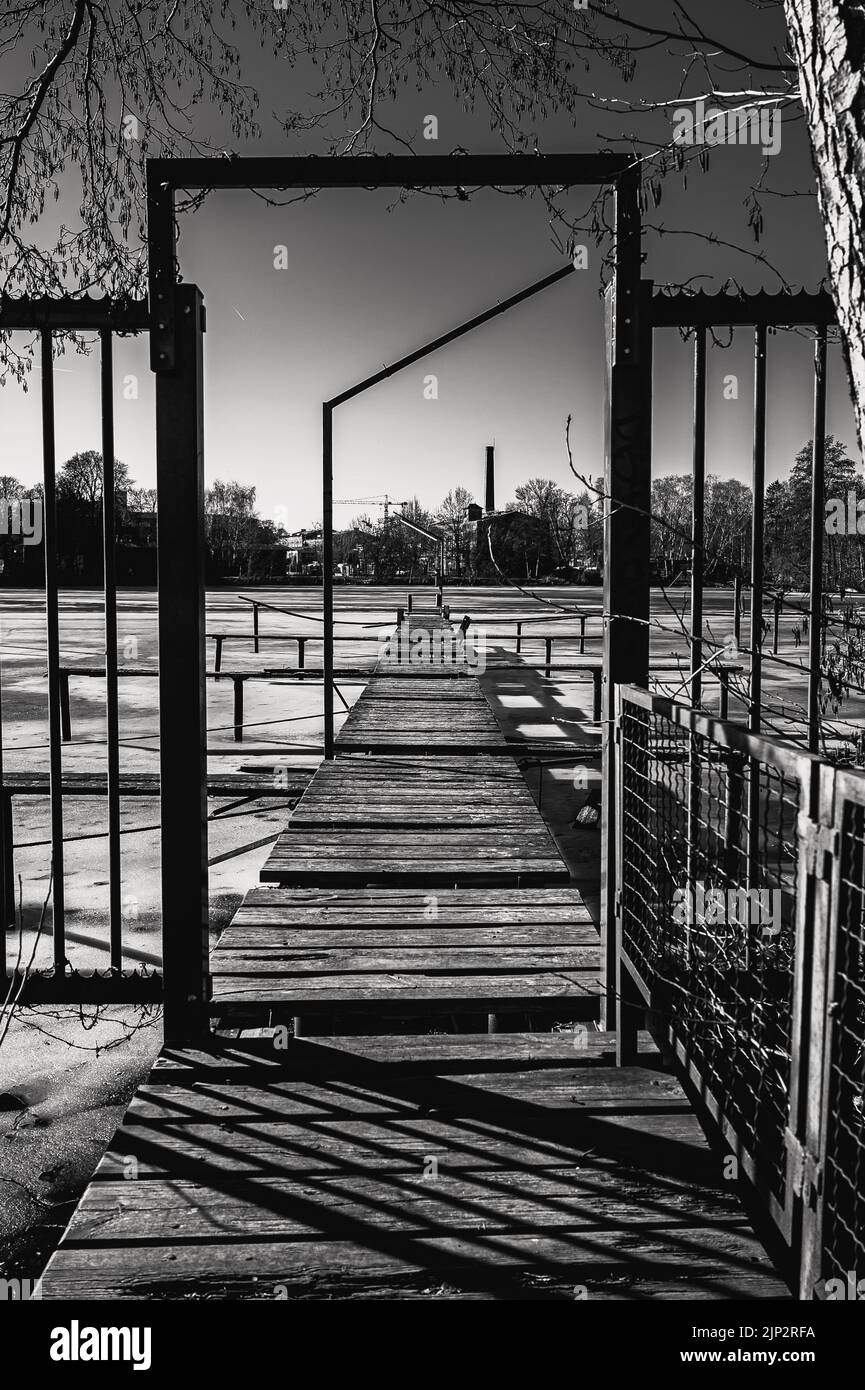 A vertical grayscale shot of a long dock with steel beam frames at a ...