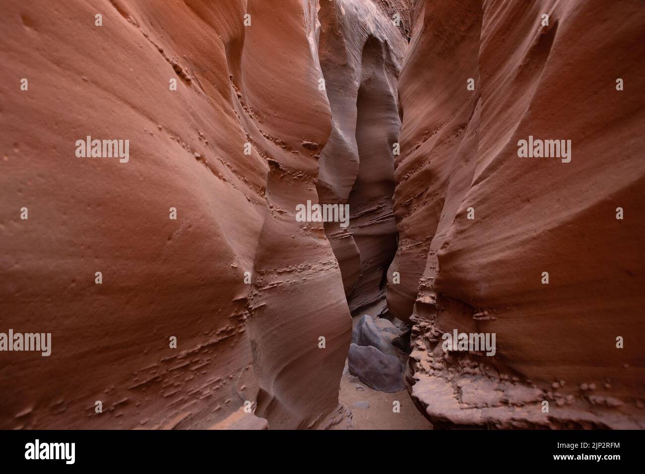 A closeup shot of a brown sandy cave with narrow passageway and ...