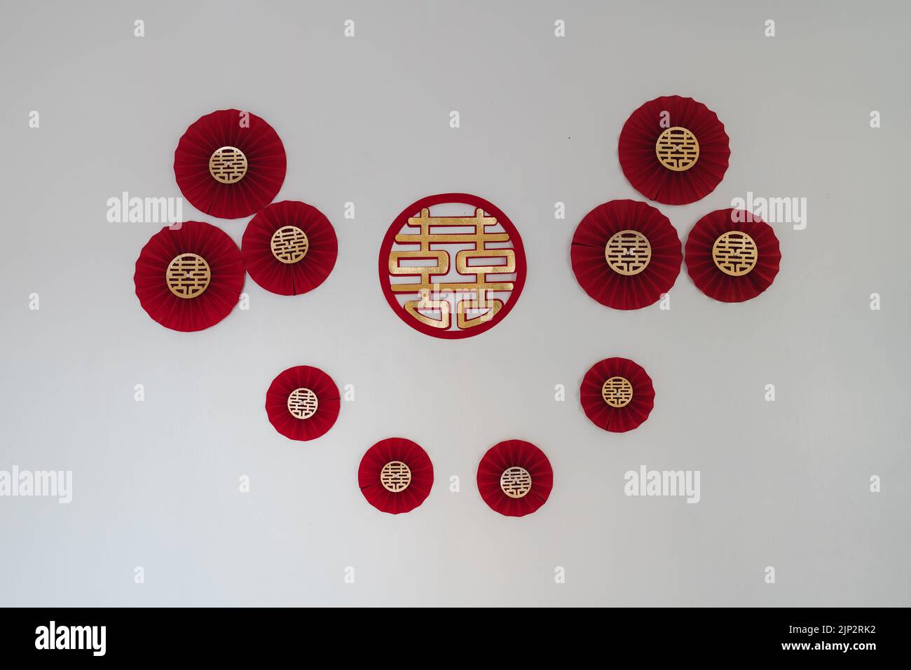 Some red paper decorations with golden designs in the middle on a gray ...