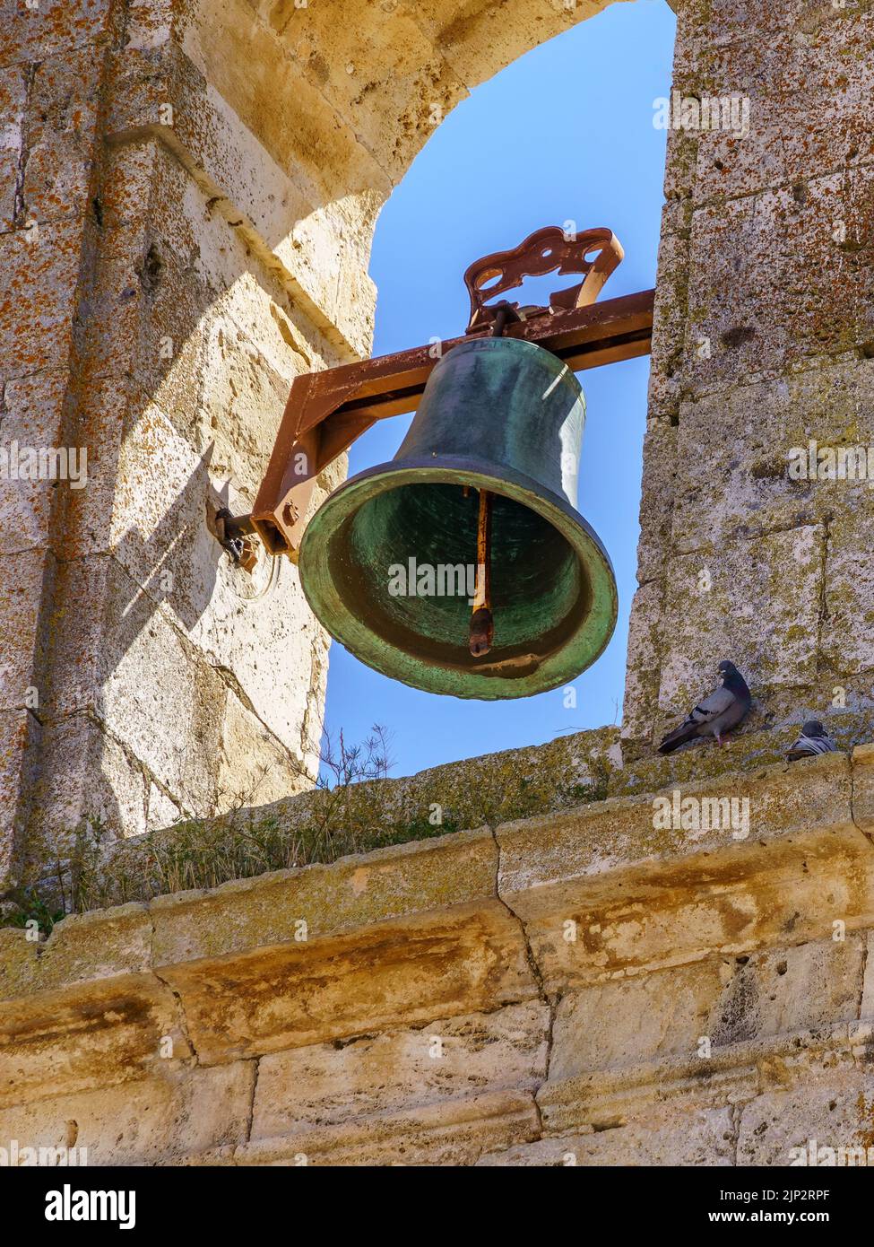 Bell in medieval stone church tower with blue sky Stock Photo - Alamy