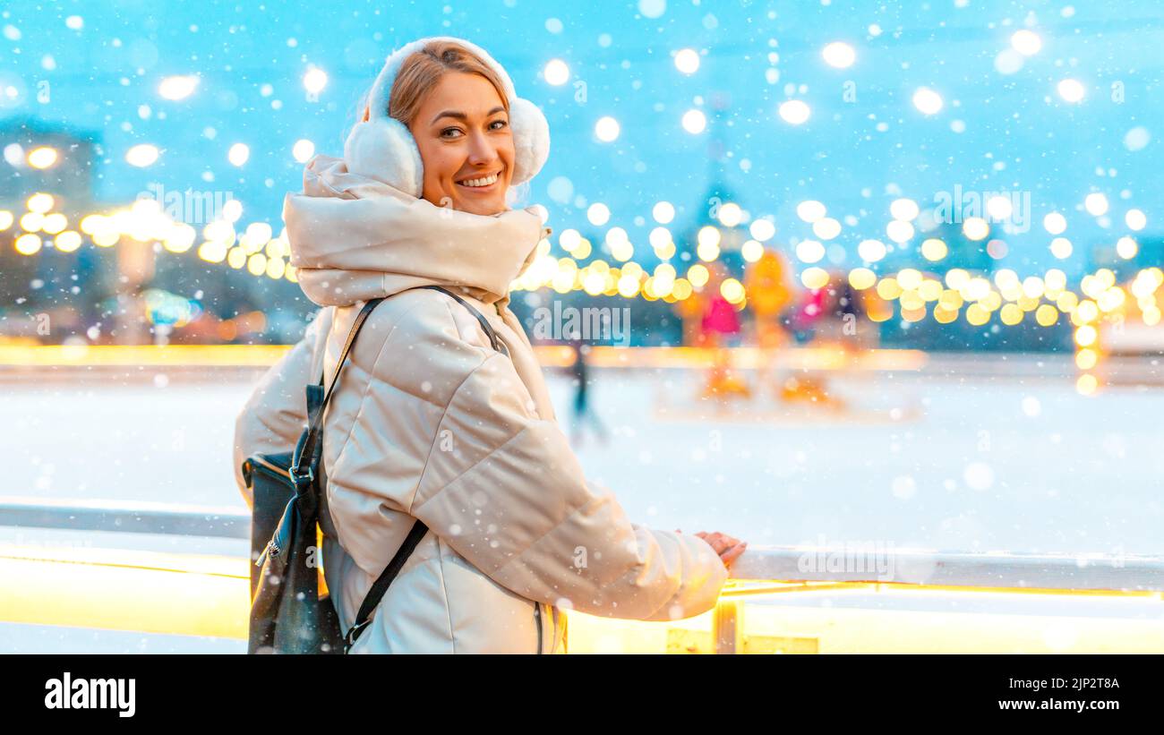 Wintertime. Christmas holiday evening, woman standing outside and smile ...
