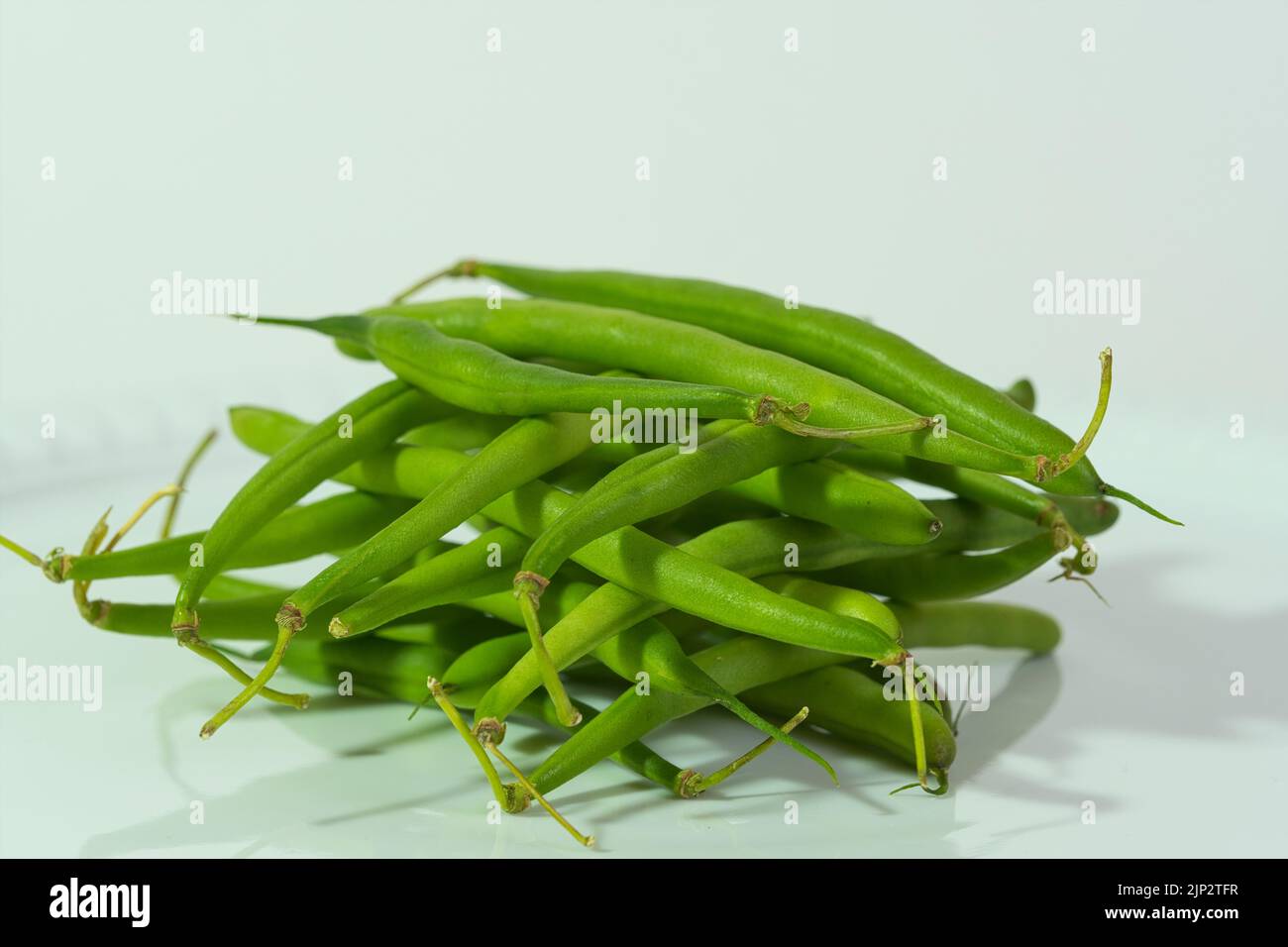 A tower of fresh green beans on white background Stock Photo - Alamy
