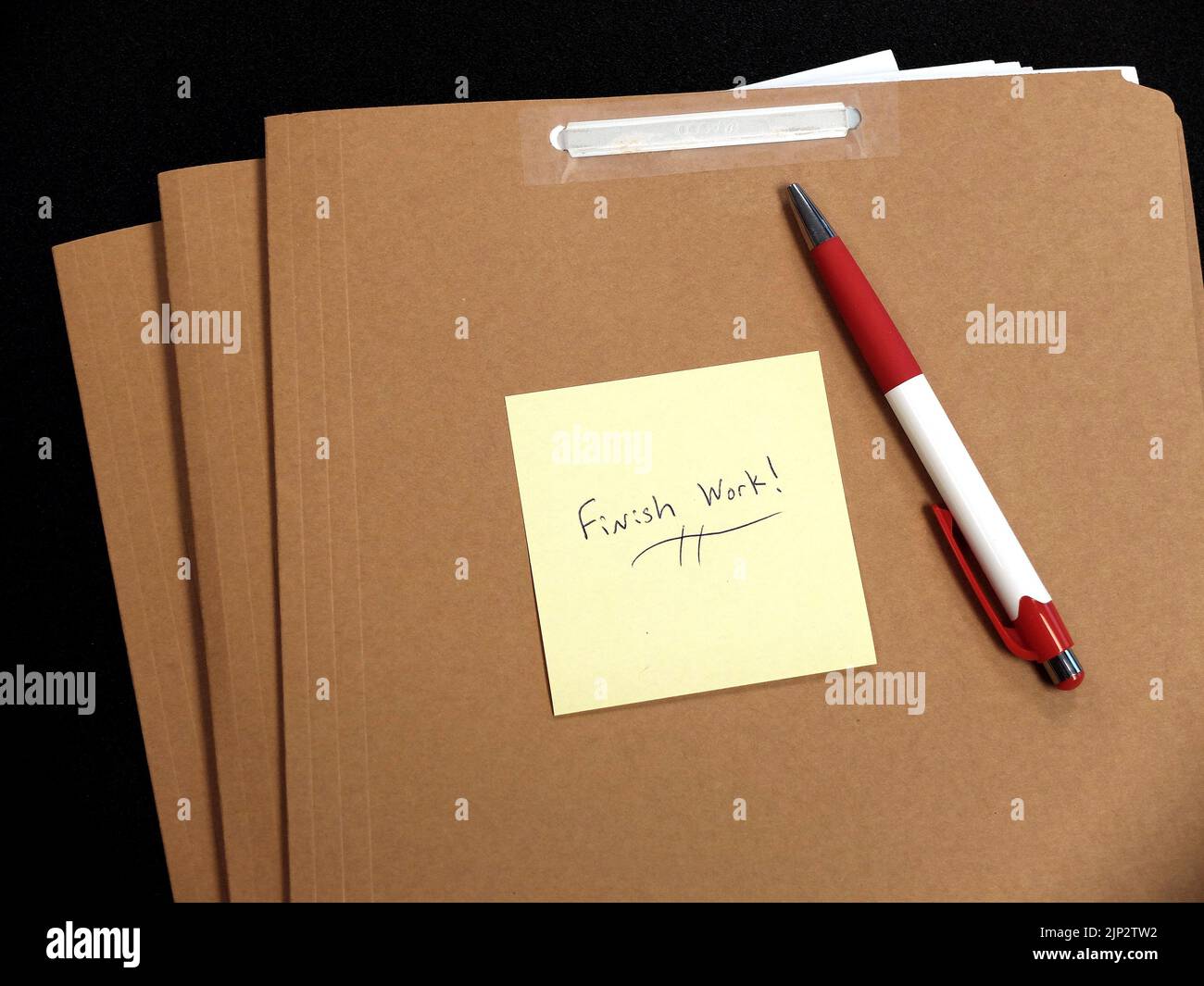 Office files on desk with pen and note to get work done and finished ...