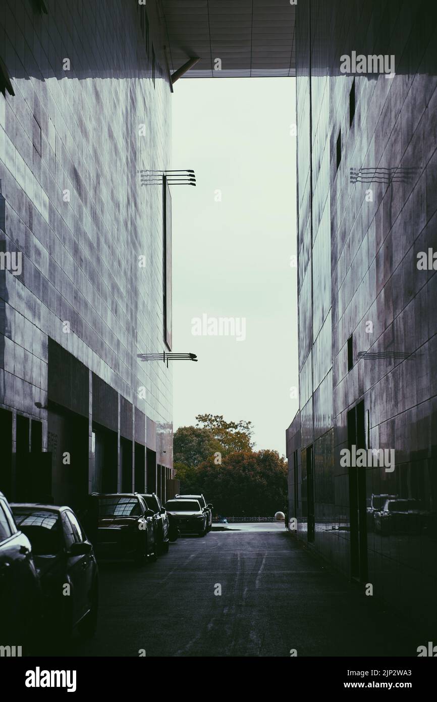 A vertical shot of cars parked between buildings Stock Photo - Alamy
