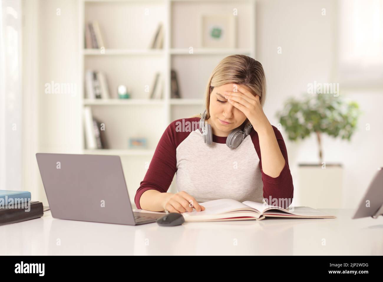 Female student sitting in front of a laptop computer at home and ...