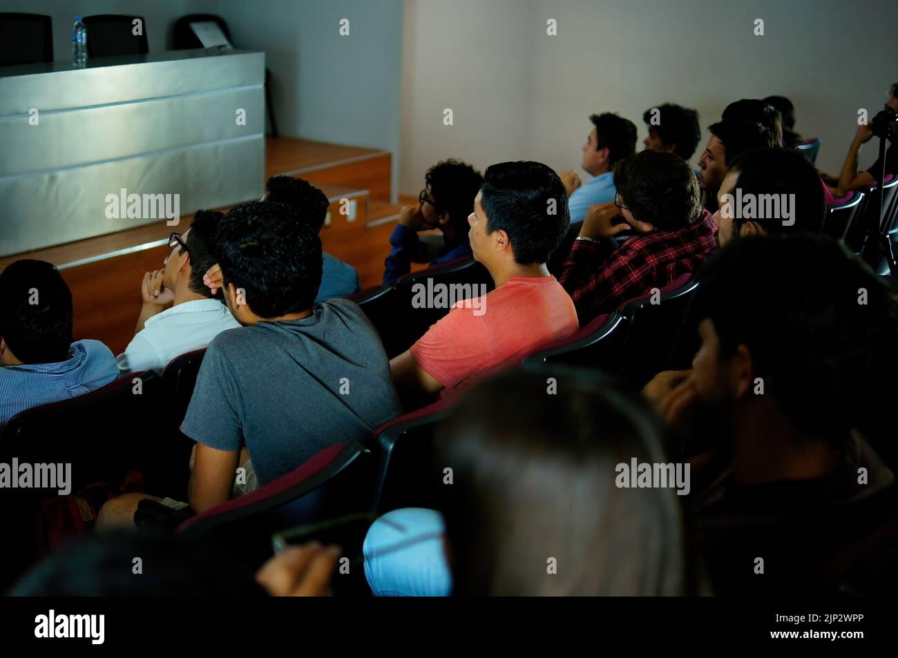 students paying attention to a lecture given by a woman, projecting ...