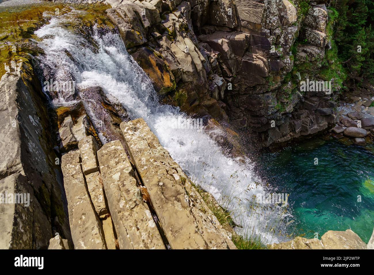 Waterfall on steps or terraces in green landscape between trees and ...