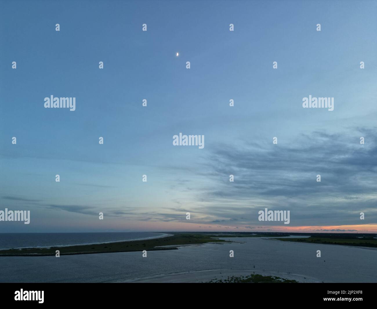 The moon rising over the ocean Stock Photo - Alamy