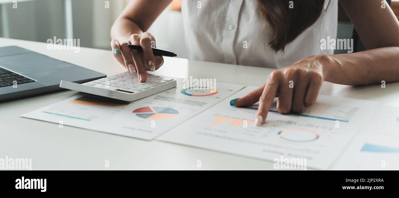 business woman or accountant working on calculator to calculate ...