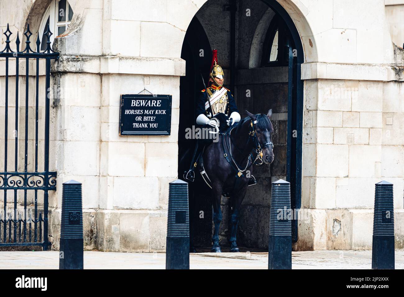 A royal guard on a horse back standing near the warning banner. London ...