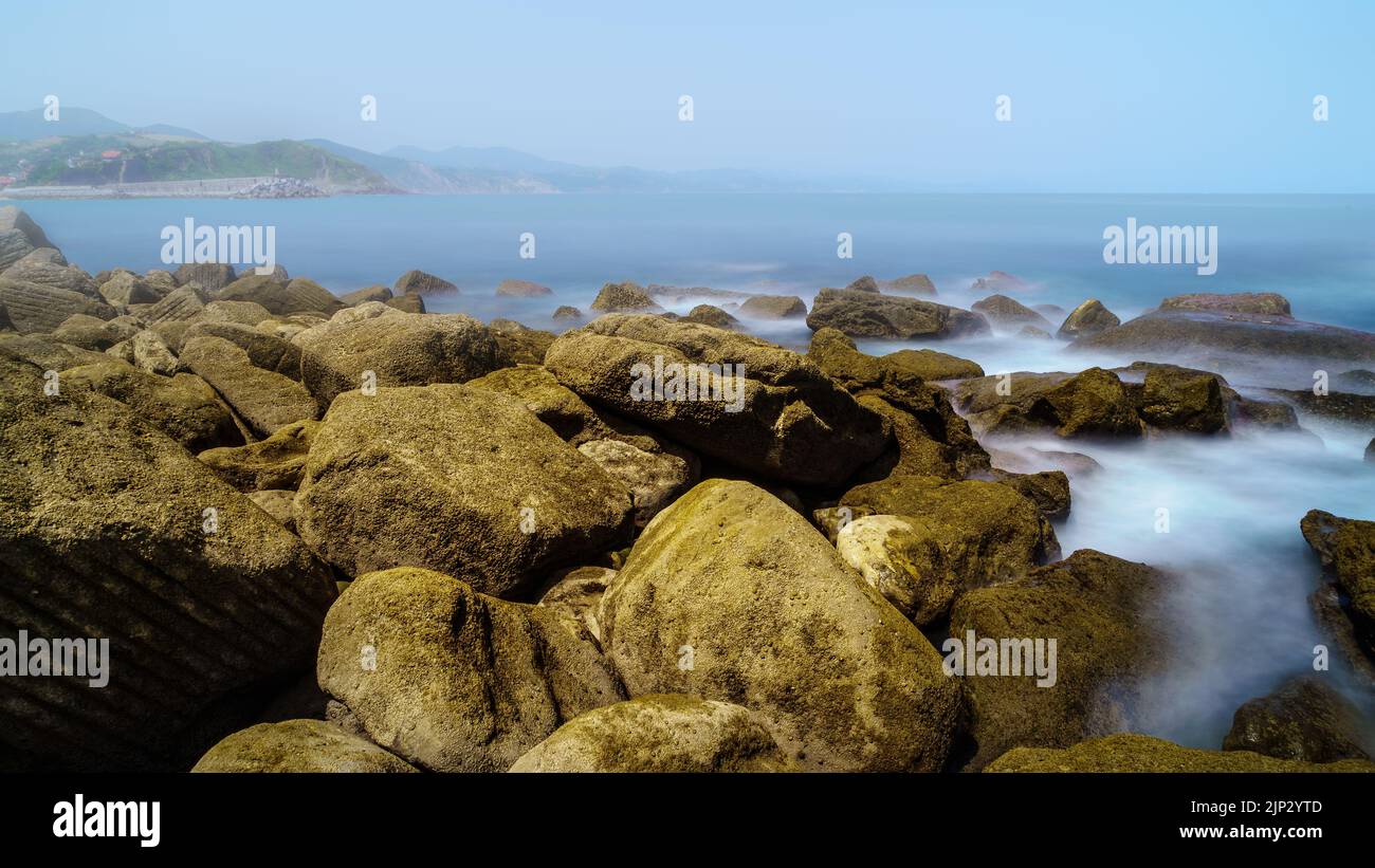 Beach of large rocks with fog and long exposure in the north of Spain ...