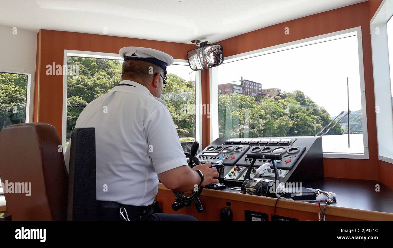 A captain steering the cruise boat in Ena Gorge (Ena-kyo) , Gifu ...