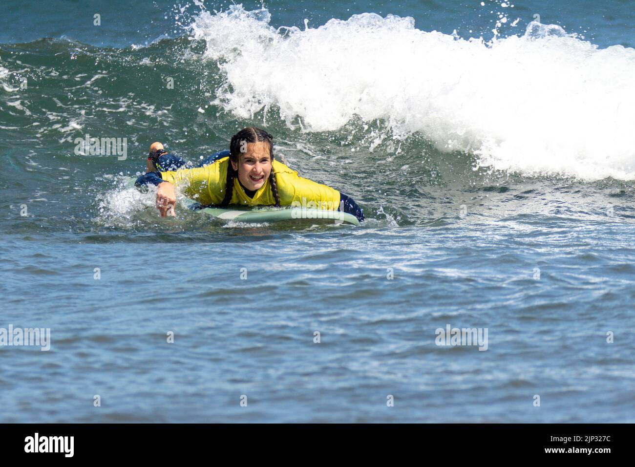 Photo with copy space of a smiley teen surfing on the sea Stock Photo ...
