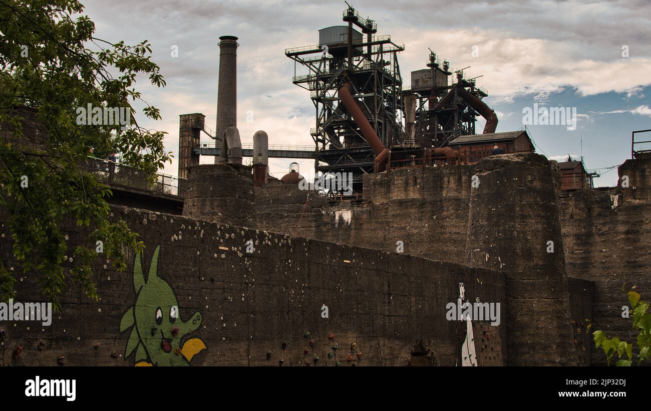 Old pipes and old mining industrial facilities behind a stone fence ...