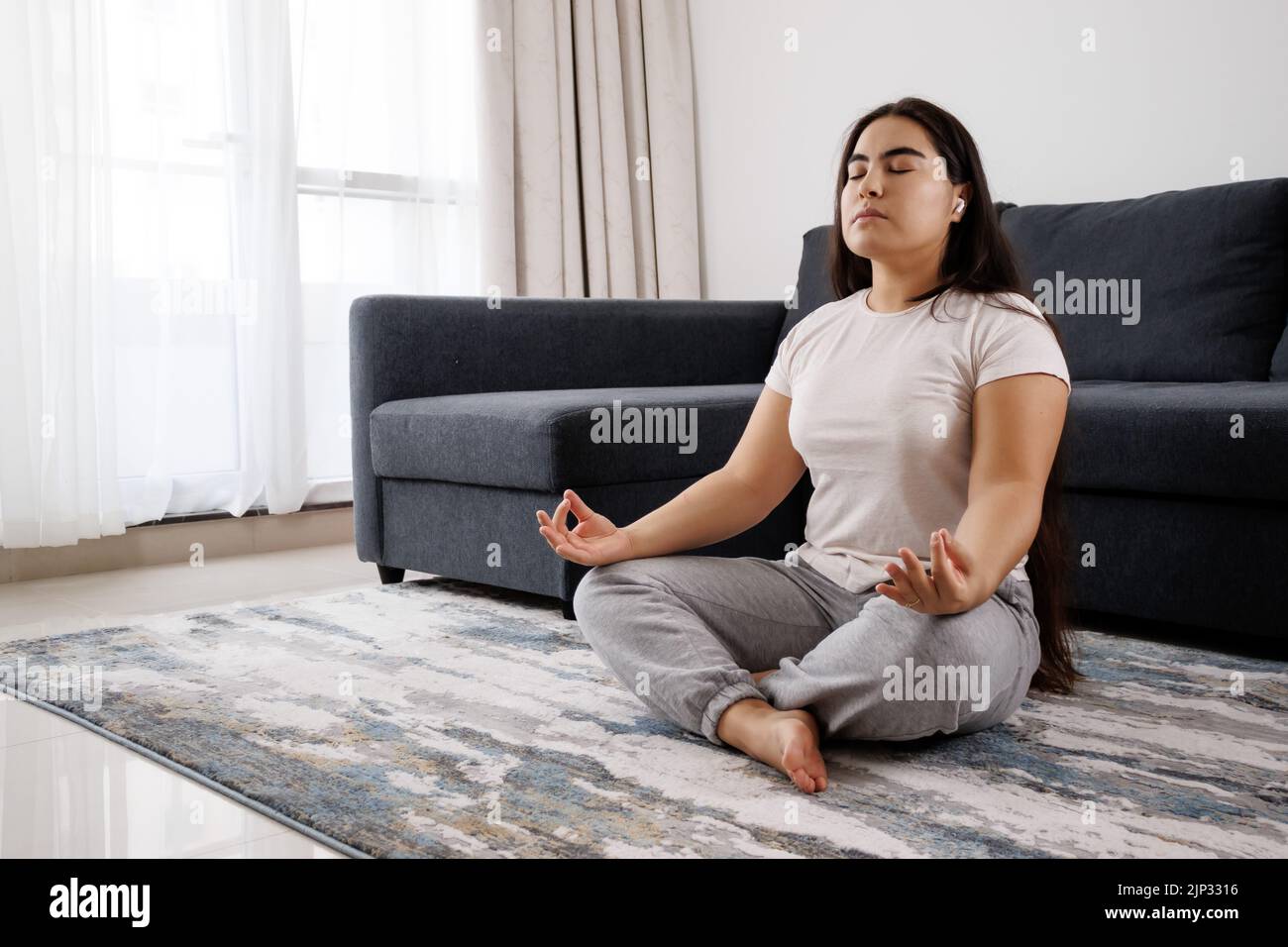 A caucasian girl doing a meditation in classic yoga pose, and self ...
