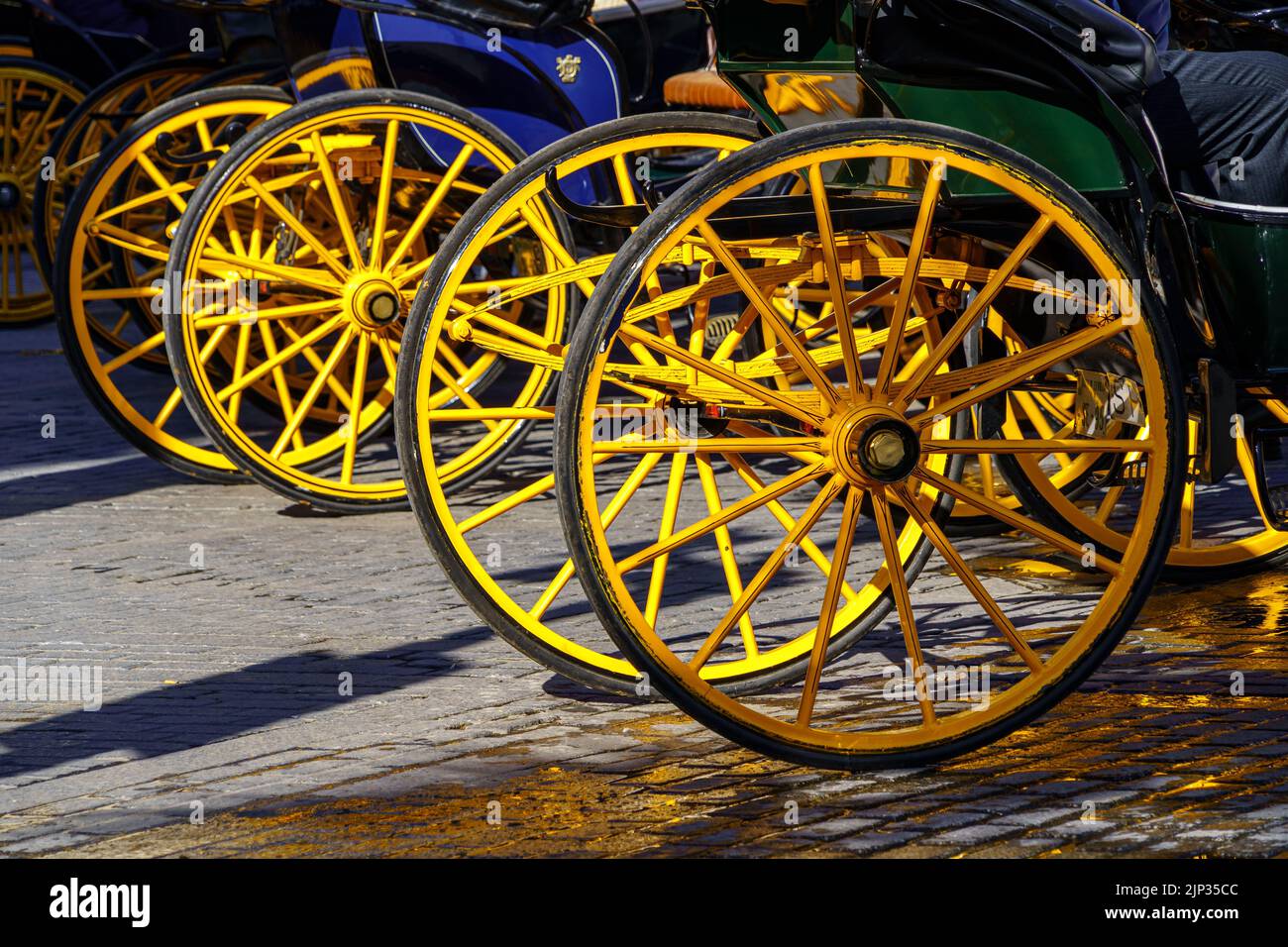 Wheels of horse carriages in the city of Seville, intense yellow color ...