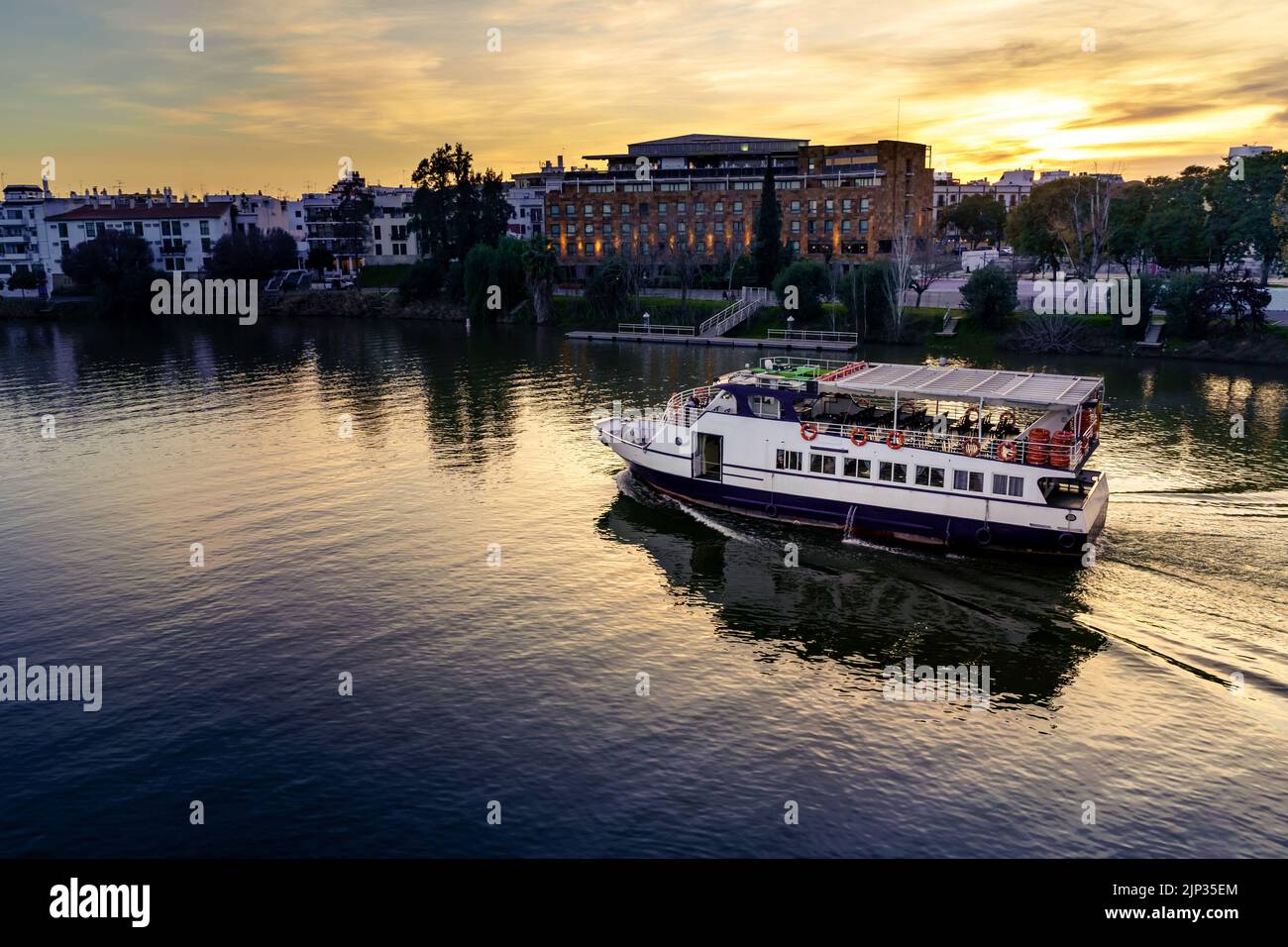 Tourist route boat on the Guadalquivir river in the city of Seville, at ...