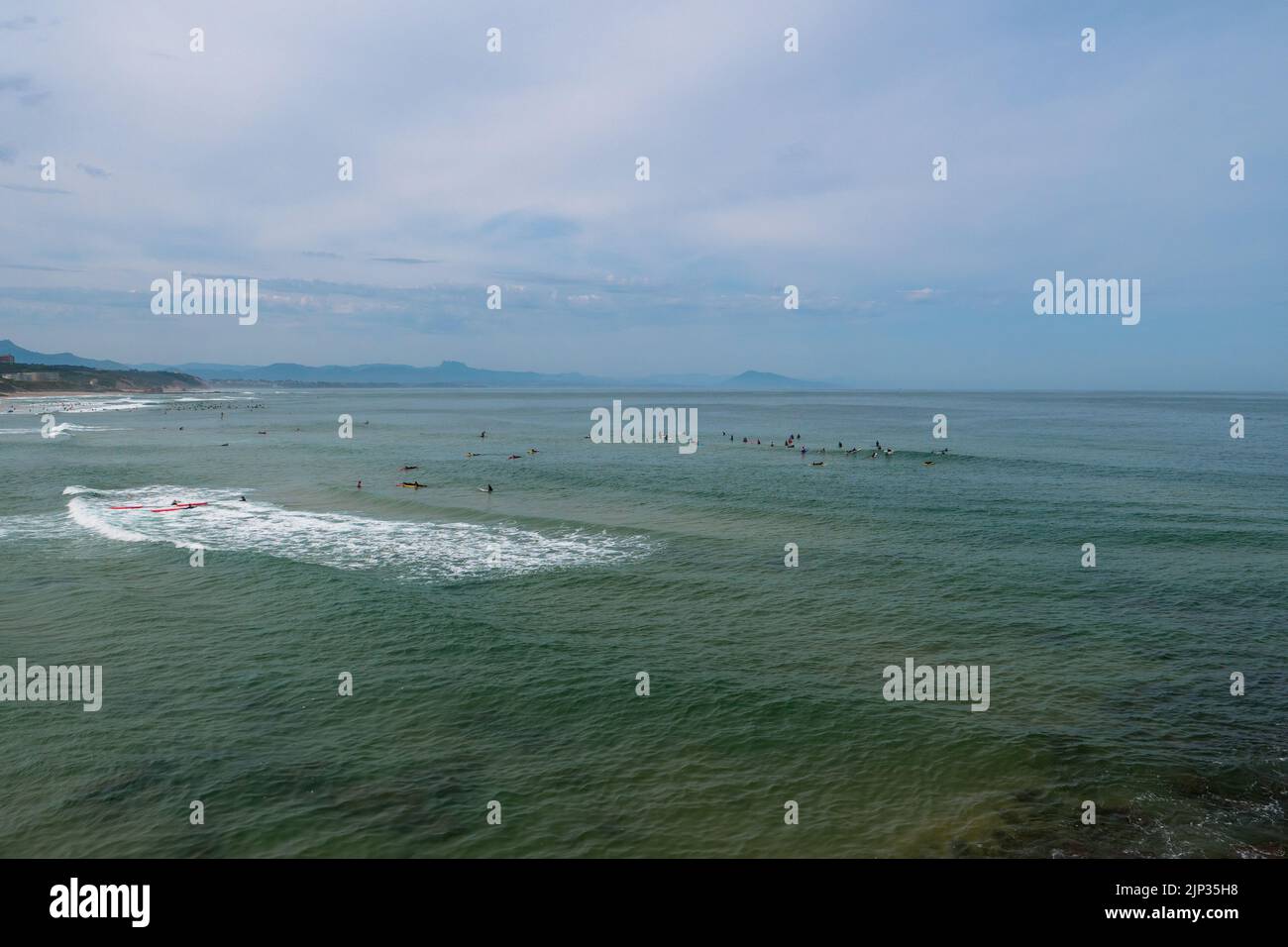 A drone shot of the surfers at Beach Cote des Basques, Biarritz, France ...