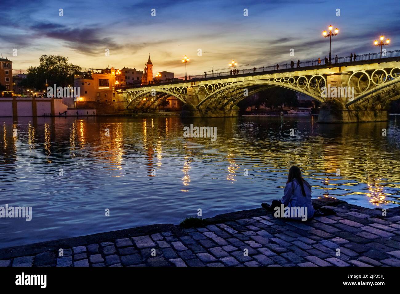 Triana bridge in Seville over the Guadalquivir river at sunset, with ...