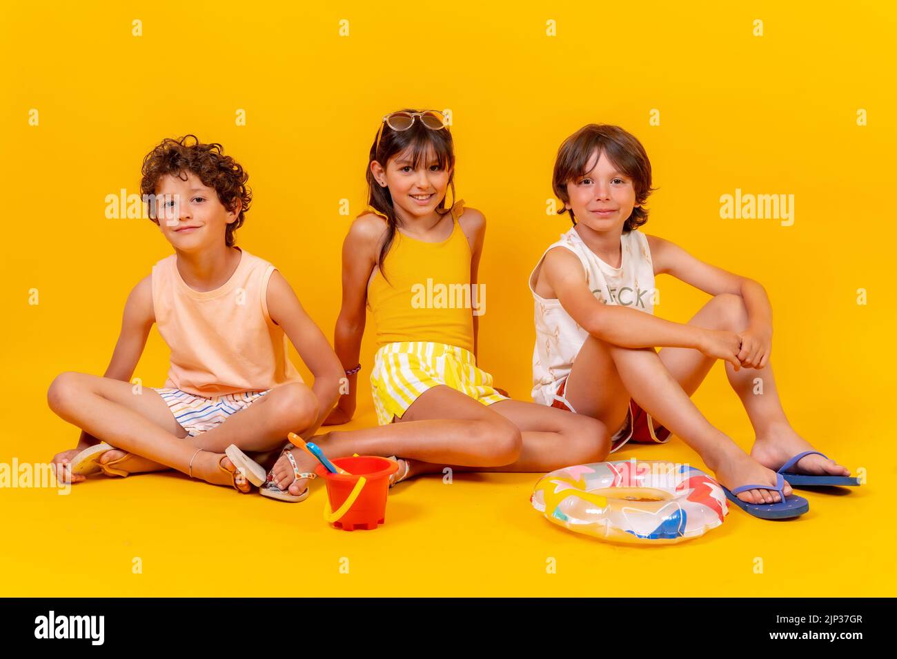 Two cute boys with a girl posing happily in summer outfits Stock Photo ...