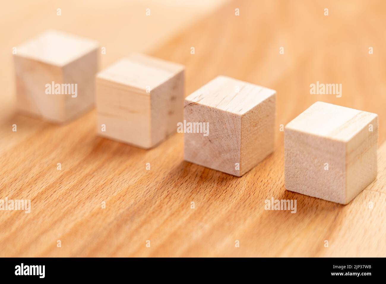Wooden cubes in a row on a wood background. Toy blocks close-up. Blank ...