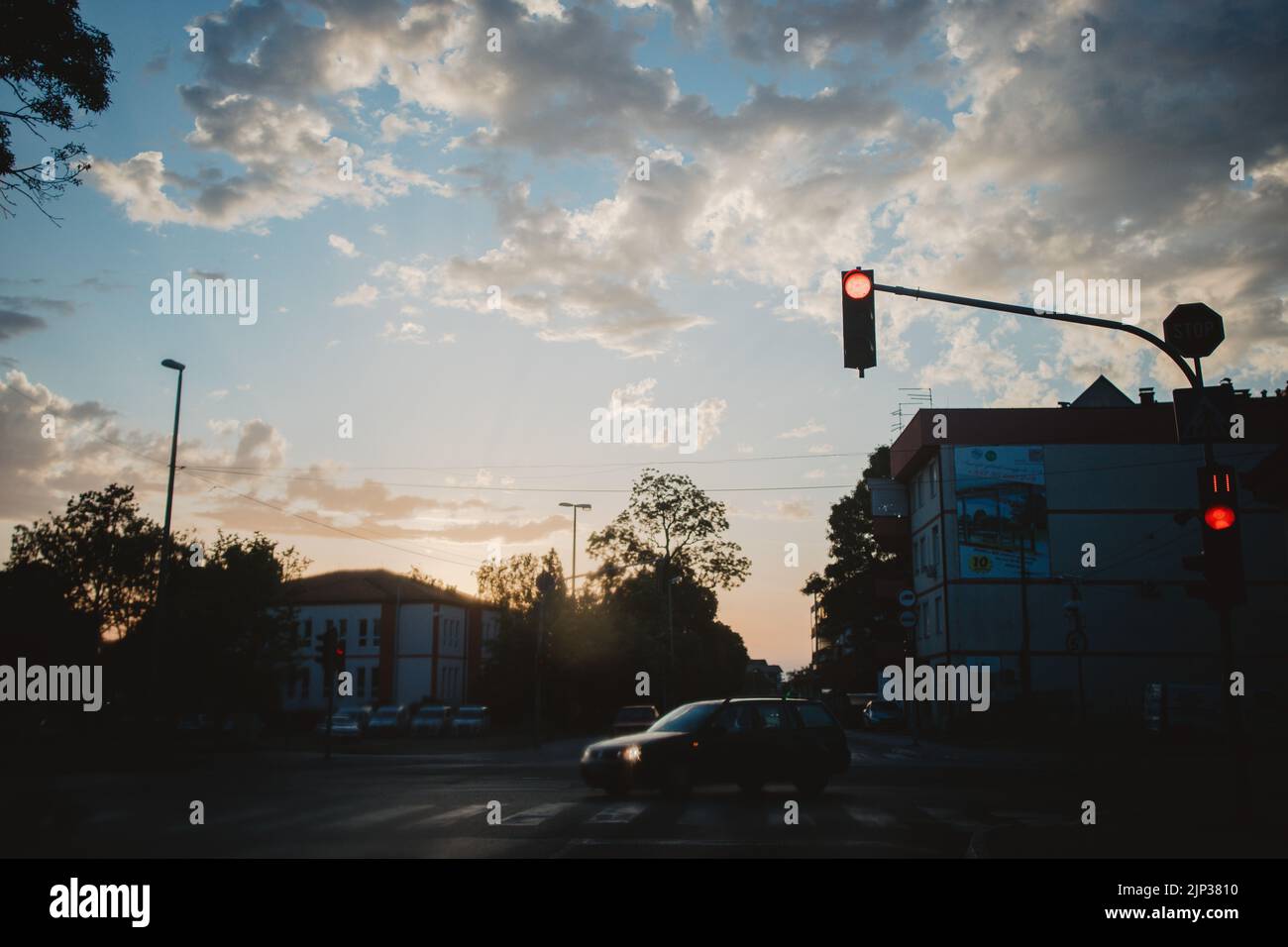 A city street with buildings and traffic lights at sunset Stock Photo ...