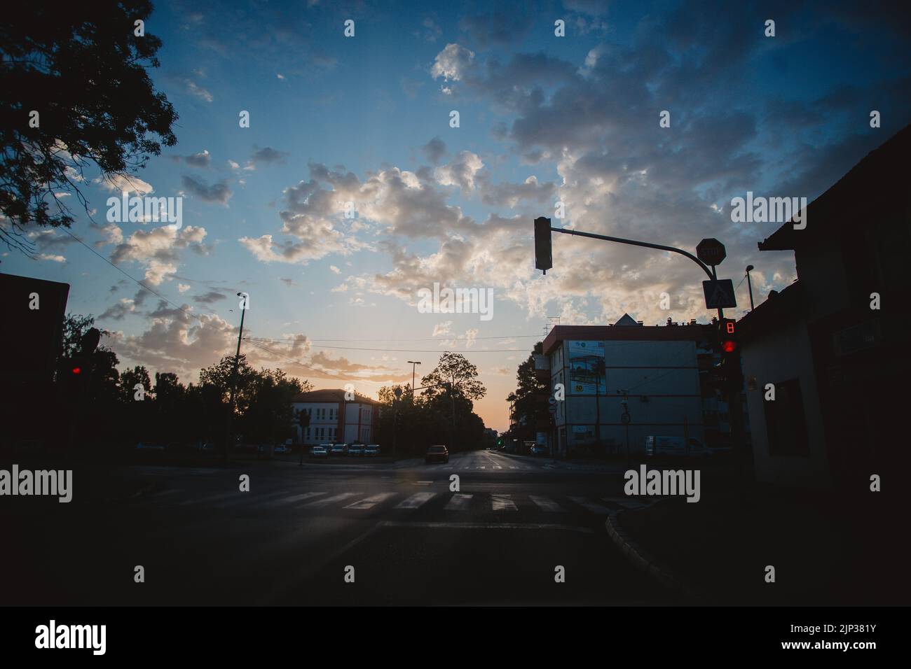 A city street with buildings and traffic lights at sunset Stock Photo ...