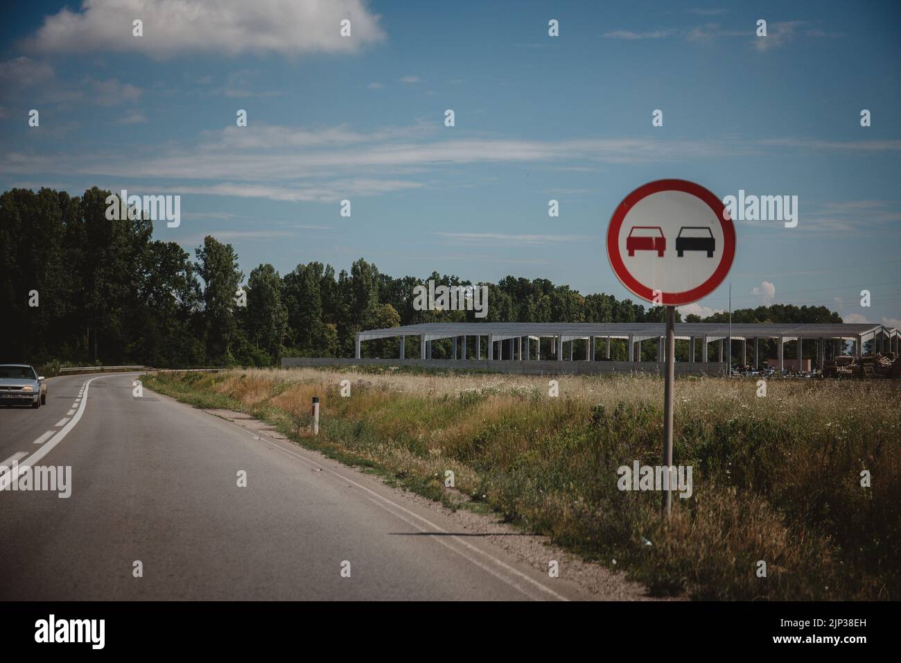 An asphalt road with an overtaking restriction sign on the side during ...