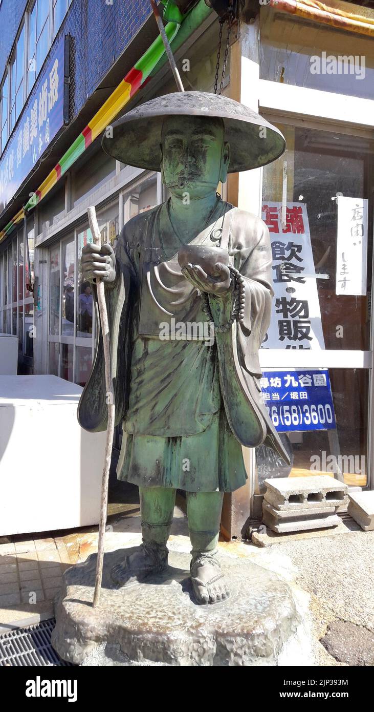 A vertical closeup of the Statue of Monk Tojinbo on the streets in ...